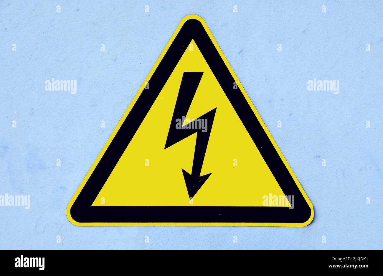 A yellow electricity warning hazard sign on a blue background Stock ...