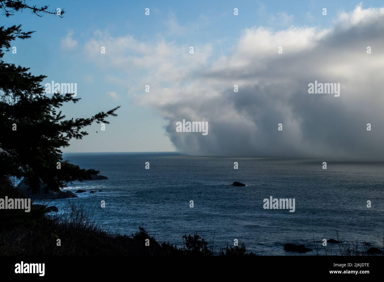 A view of white and grey clouds gathering over a body of water near the ...