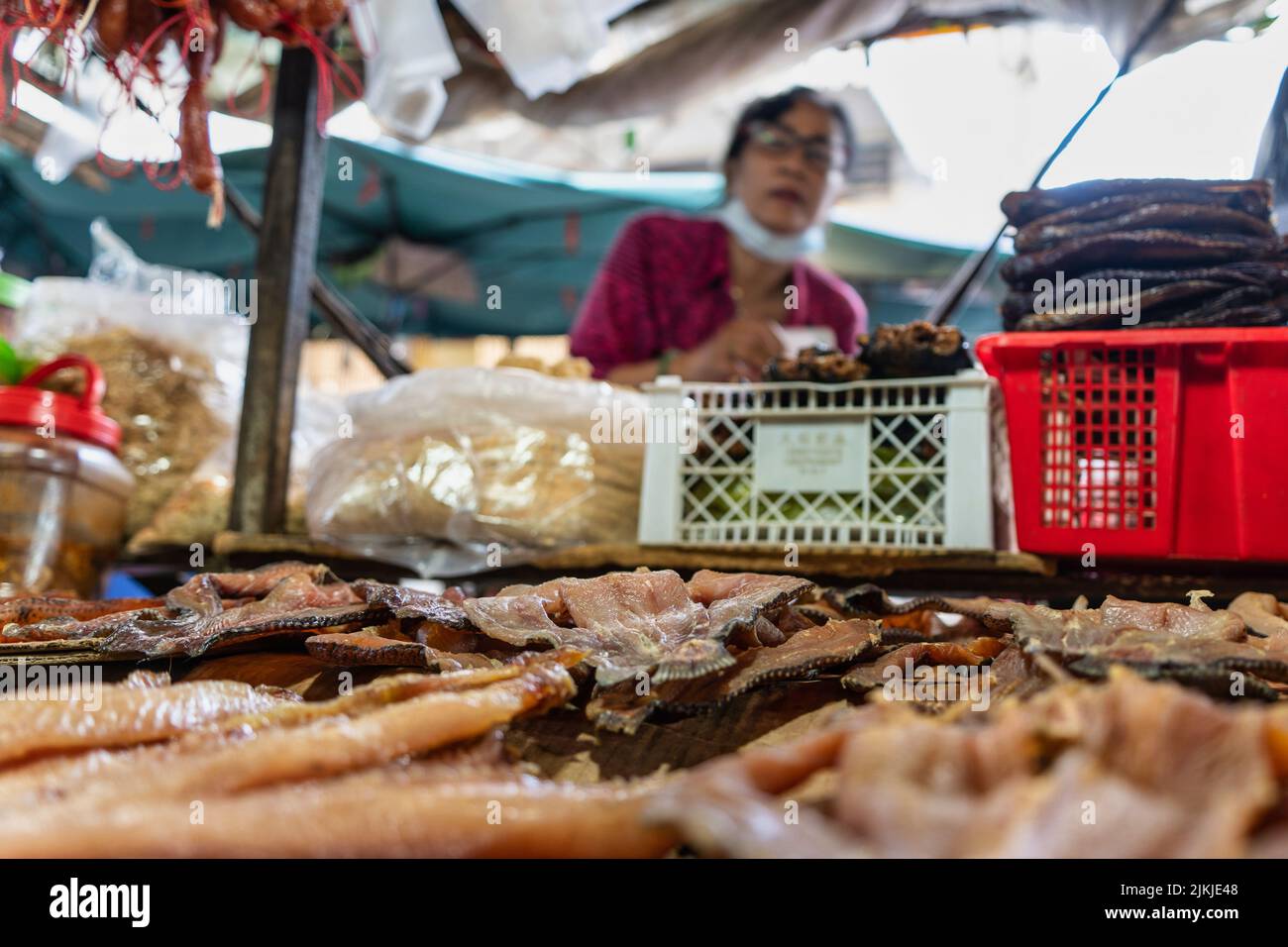 A view of a dry fish vendor in a Phnom Penh food market under colorful ...