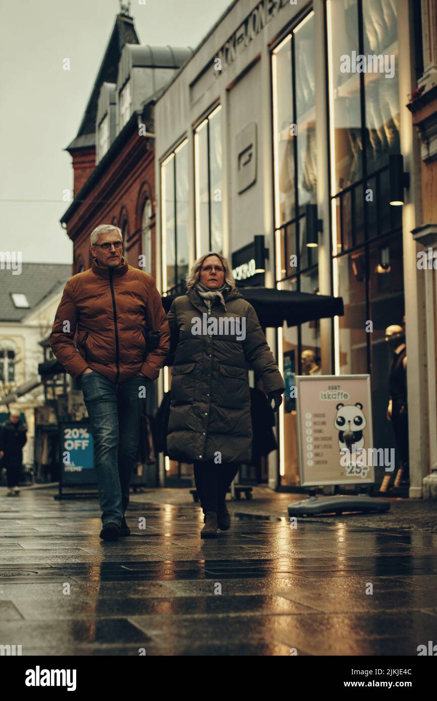 A vertical shot of an elder couple walking on the streets of Holstebro ...