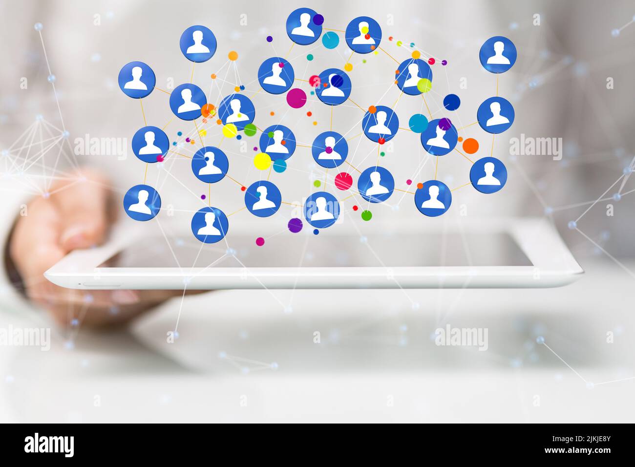 A hologram of interconnected people projecting from a man's tablet ...