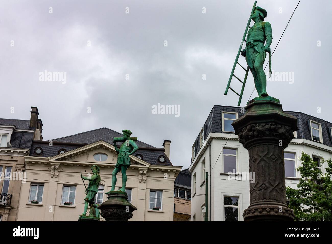 A low angle shot of blue bronze statues surrounding the Petit Sablon ...