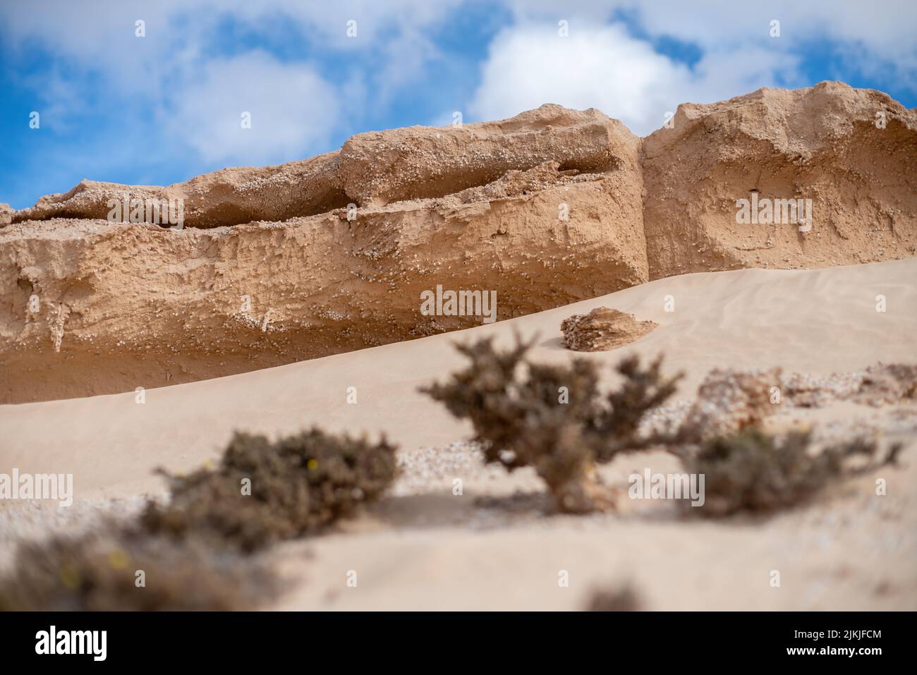 A view of a rock formation in a sandy desert isolated on a blurred ...