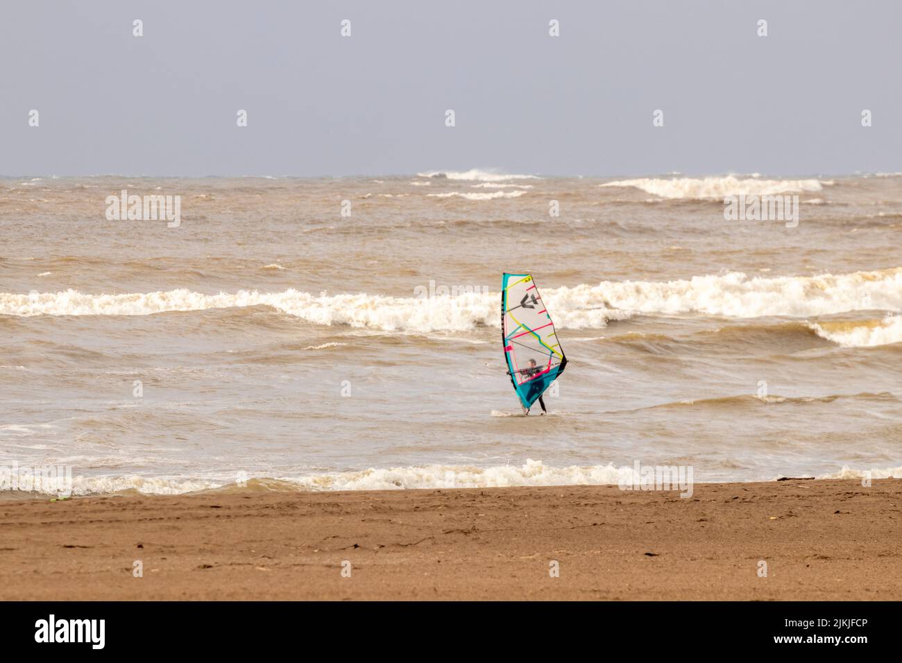 A person windsurfing on a cloudy day in the Cantabrian sea near Bilbao ...