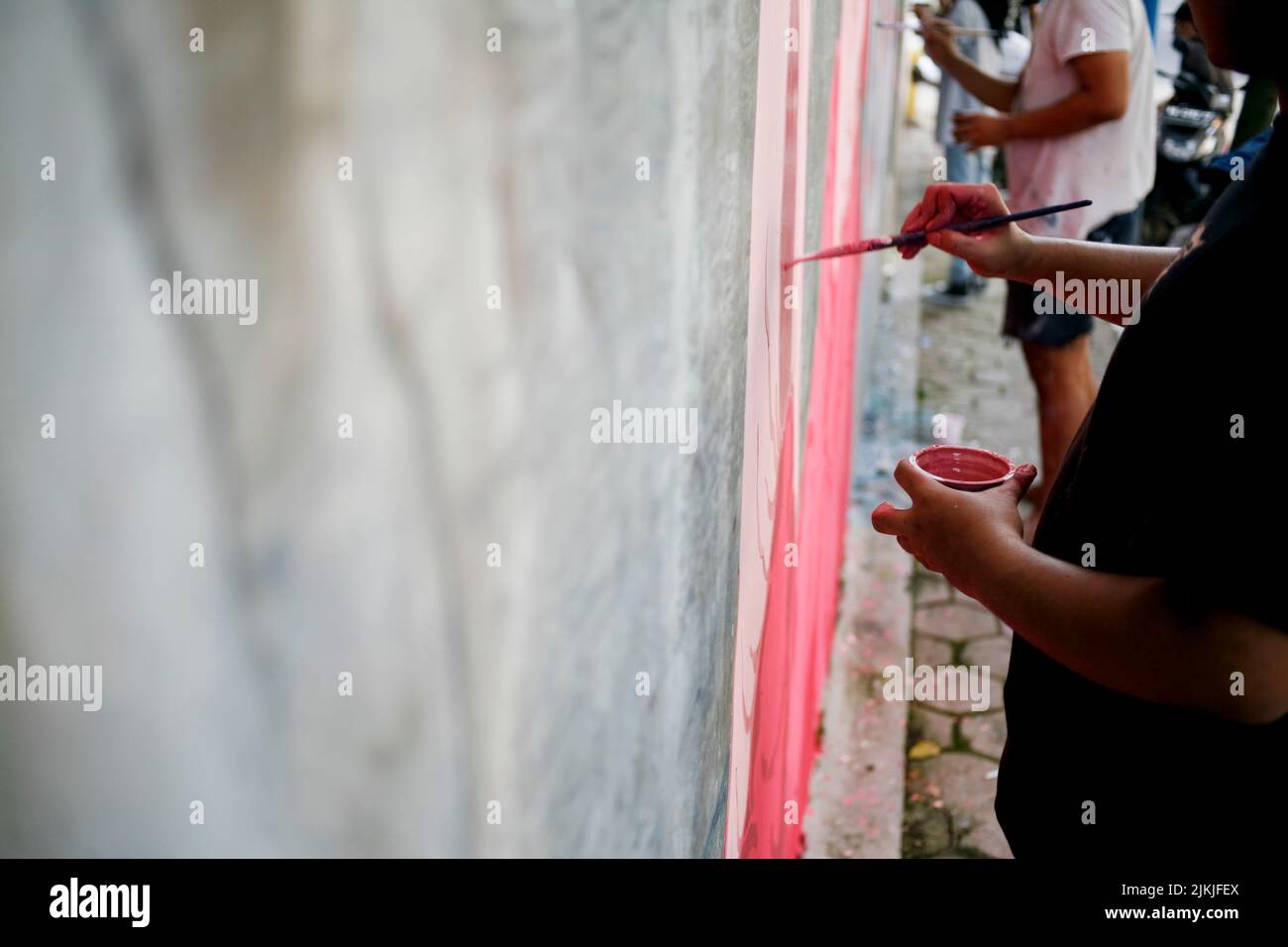Artist hand drawing paint on the wall Stock Photo - Alamy