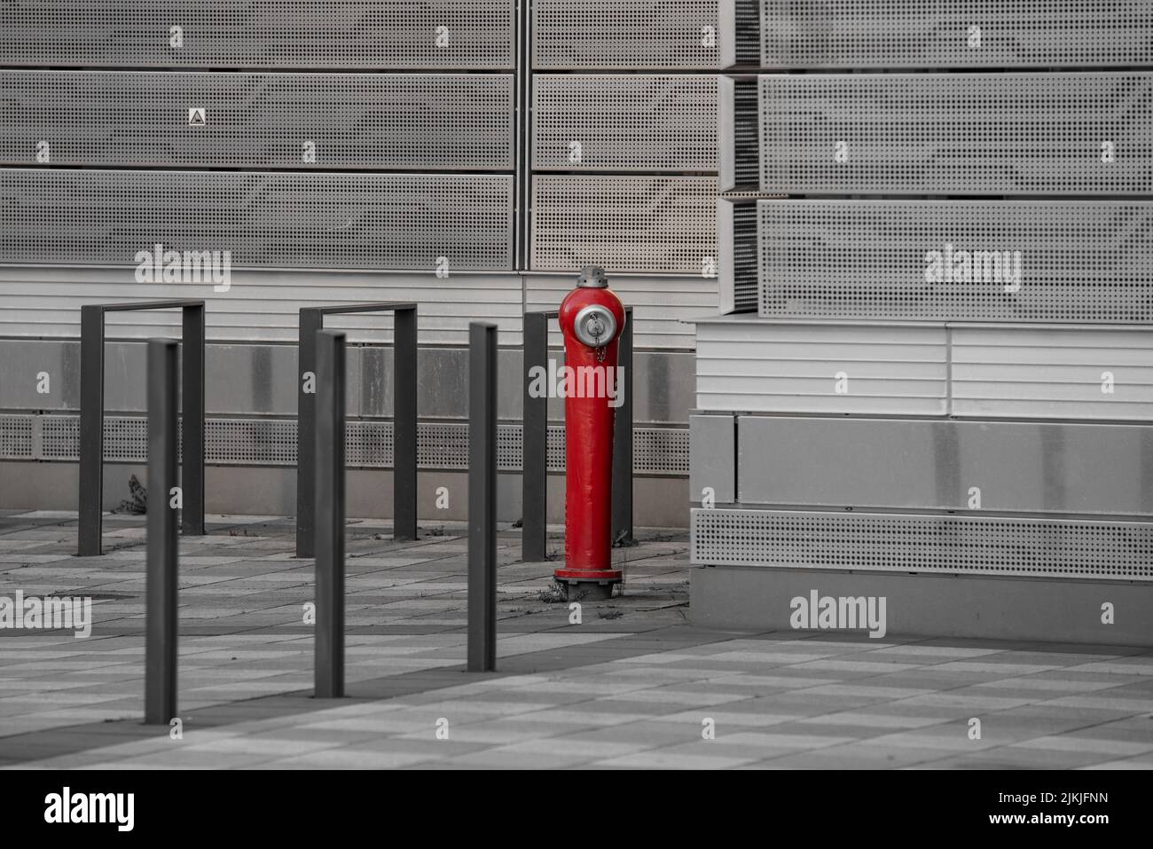 A red fire hydrant near a gray building Stock Photo - Alamy