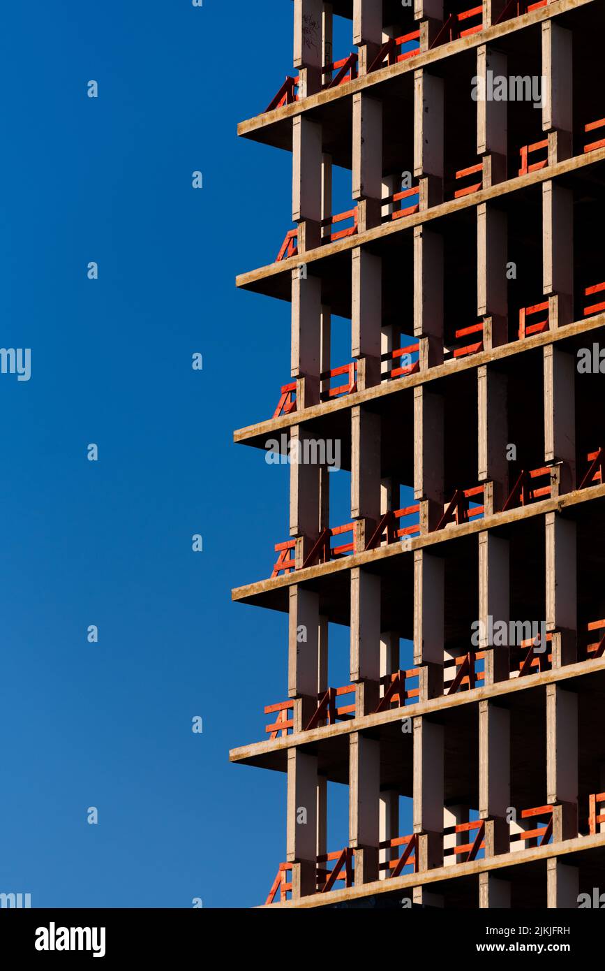 A vertical shot of a part of a building with columns against the blue ...