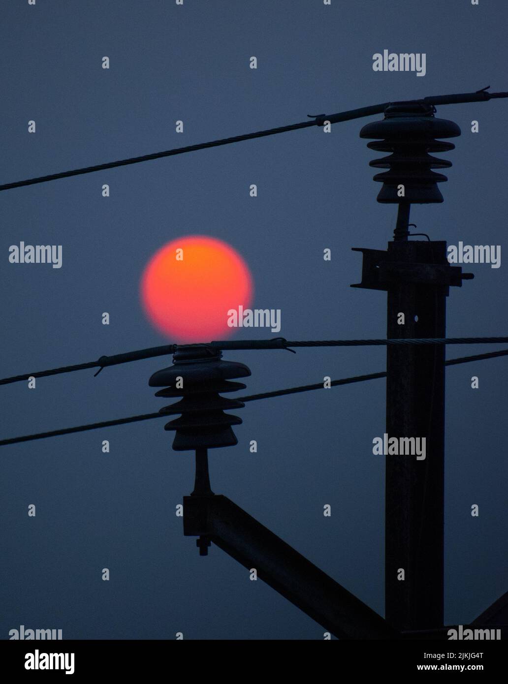 A vertical shot of sunset on top of an electric wire pole Stock Photo ...