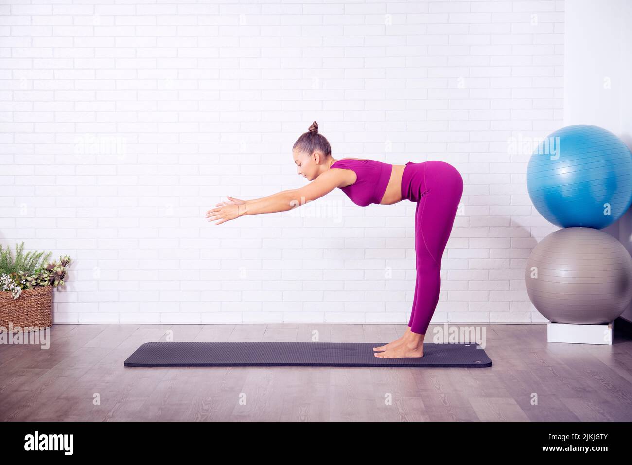 A fit yoga instructor demonstrating yoga positions in a studio Stock ...