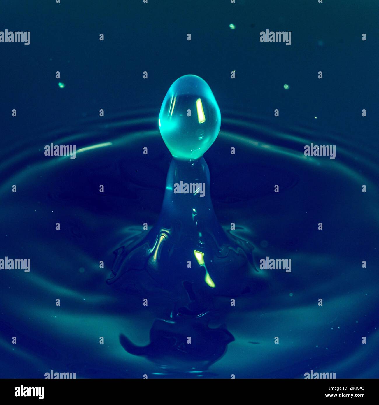 A vertical shot of one drop of water with dark blue backlight - perfect ...