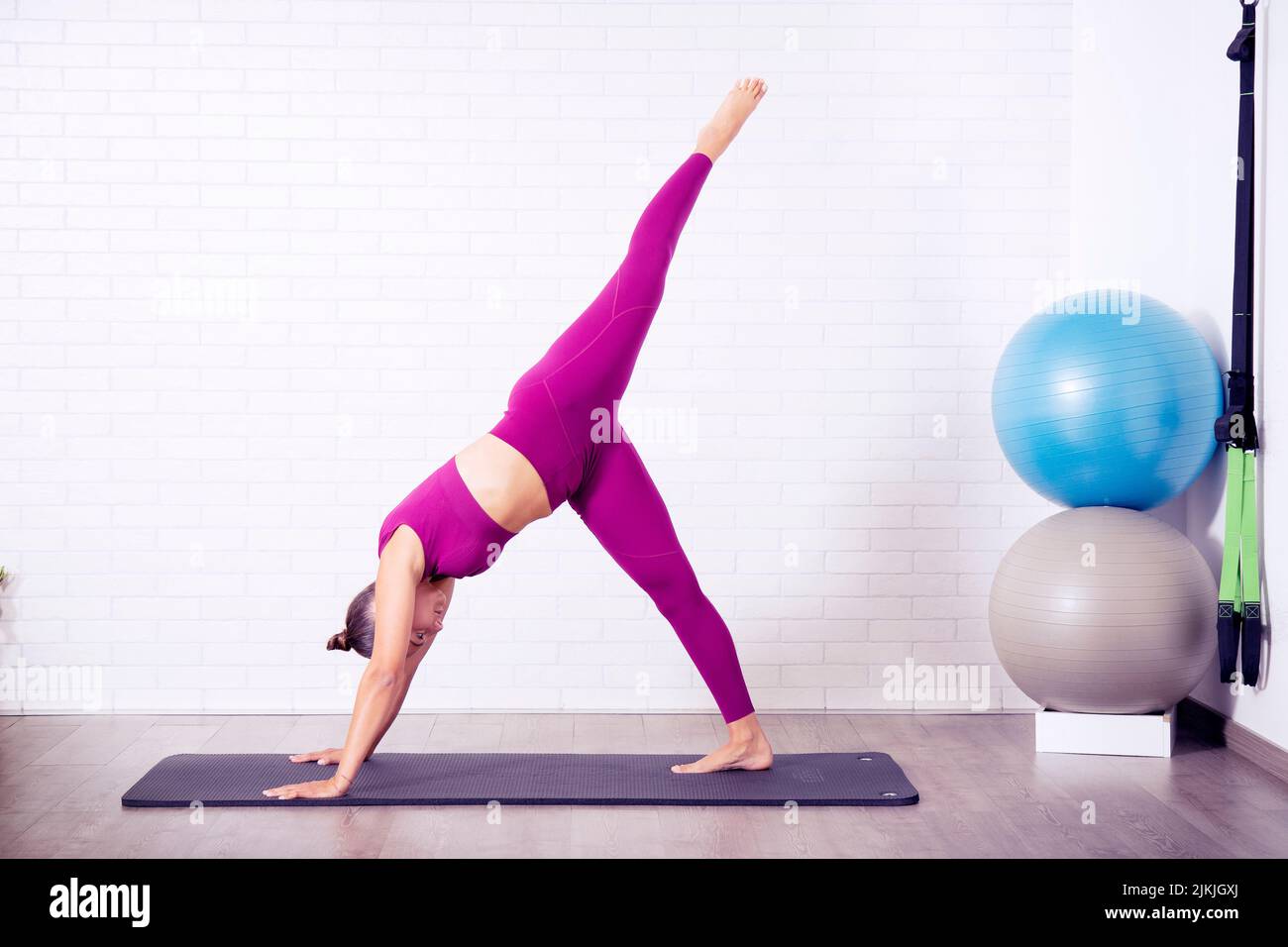 A fit yoga instructor demonstrating yoga positions in a studio Stock ...