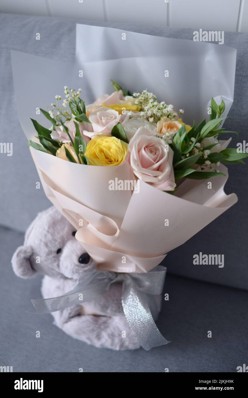 A cute teddy bear and a flower bouquet Stock Photo - Alamy