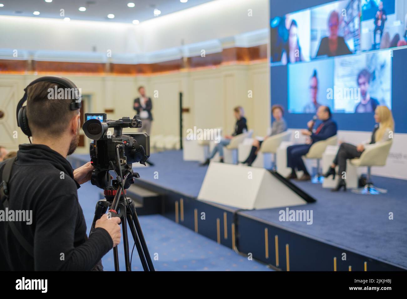 Cameraman shooting stage during business seminar Stock Photo - Alamy