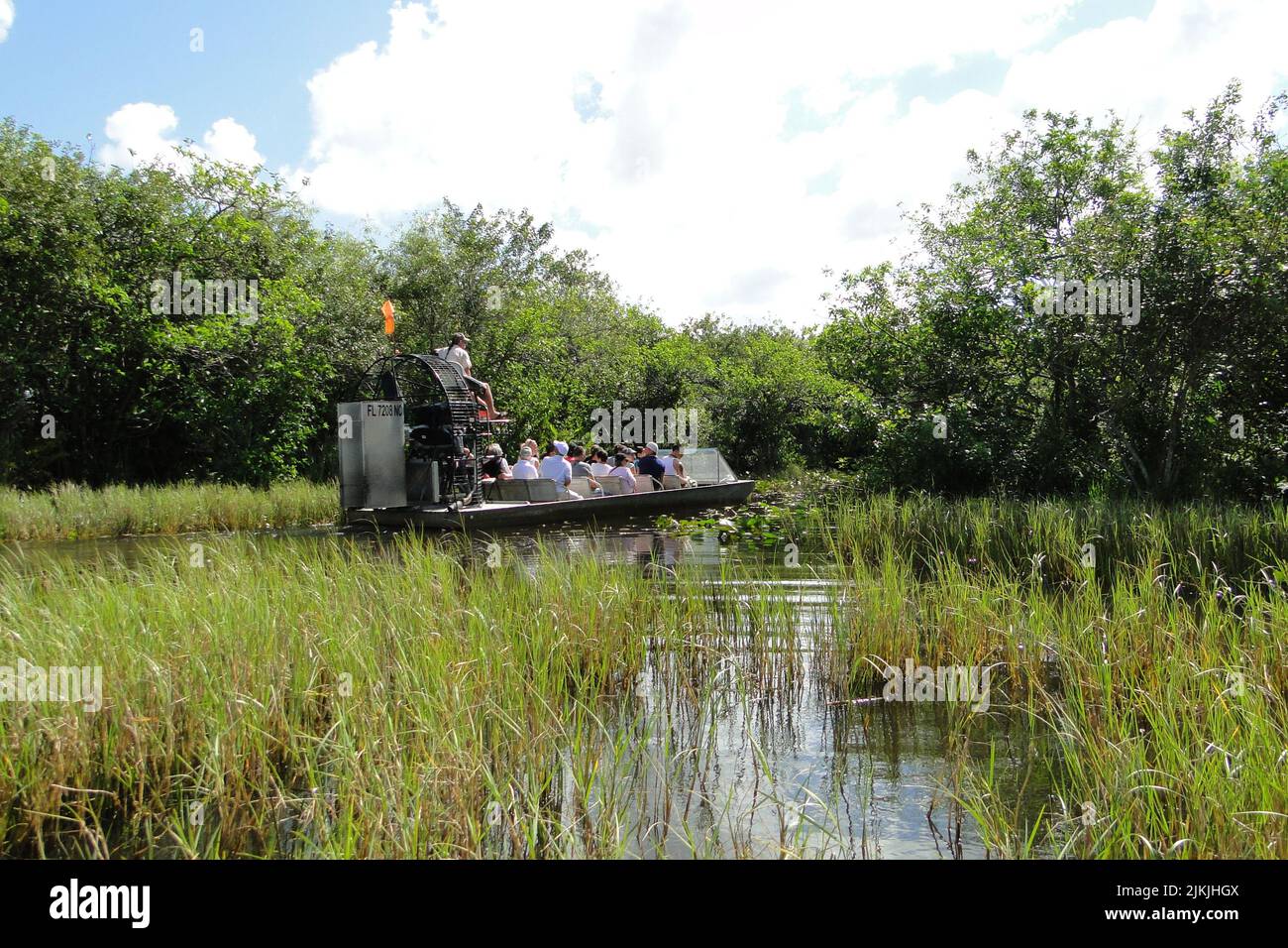 A bright summer day with people riding on the Swamp boat tour in the ...