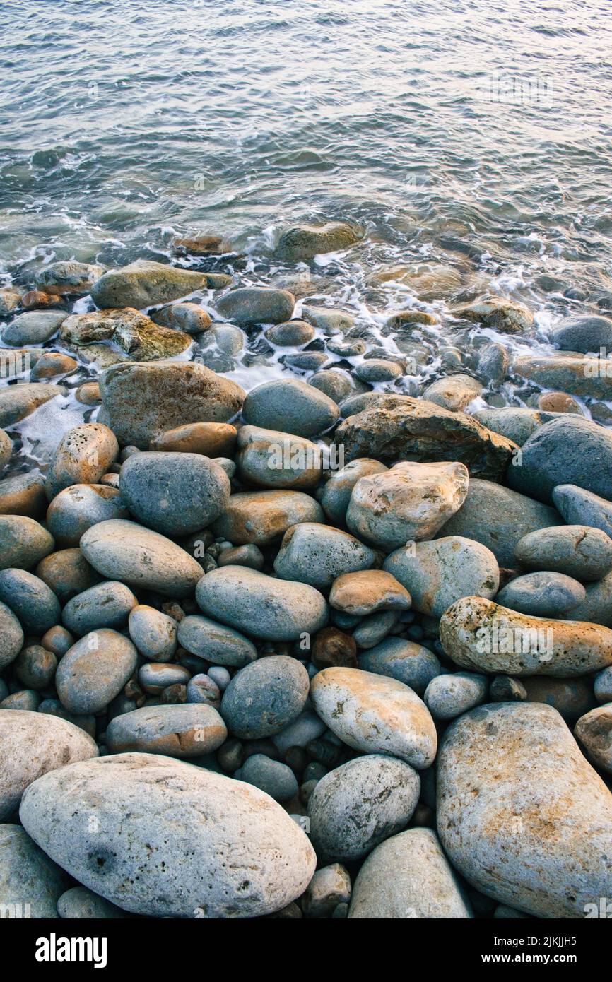 A vertical shot of pebbles on a sea Stock Photo - Alamy
