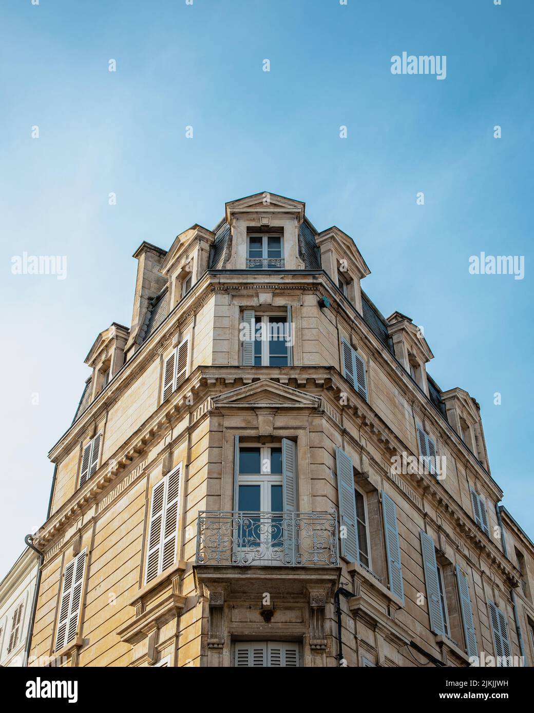 A vertical low angle shot of a classic French style building under a ...
