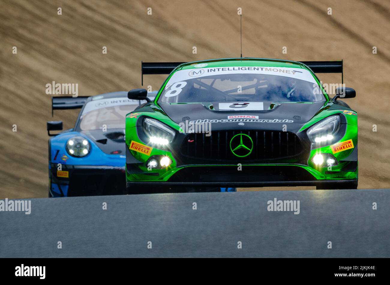 A low angle shot of a Mercedes-AMG GT3 black car and Porsche 911 GT3 ...