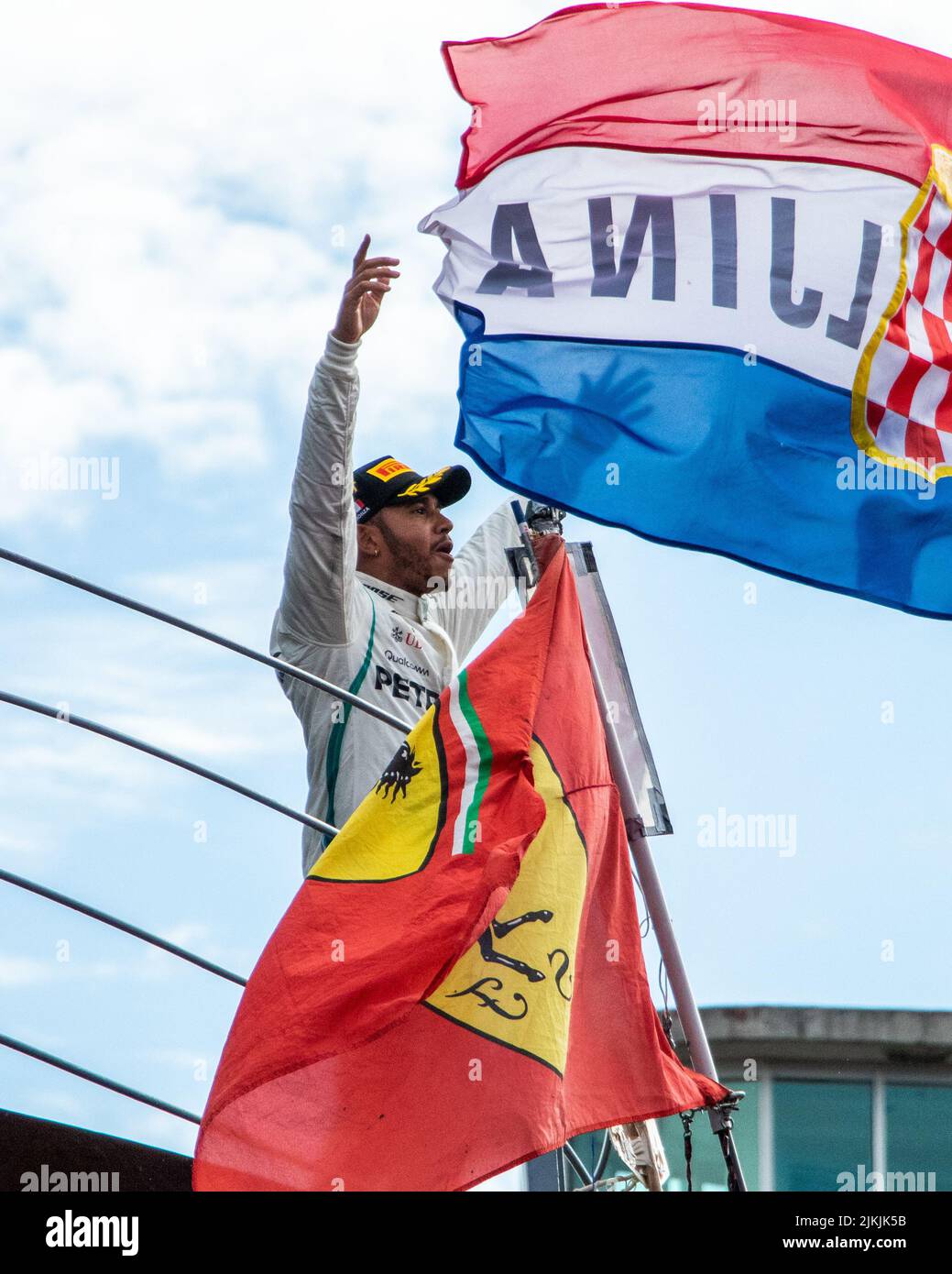 A low angle shot of Lewis Hamilton celebrating a win with flags in the ...