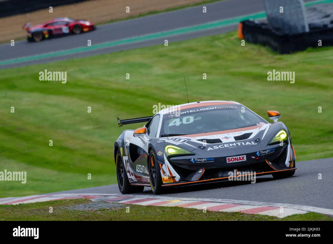 A low angle shot of a McLaren 570 GT4 black car during the race in the ...