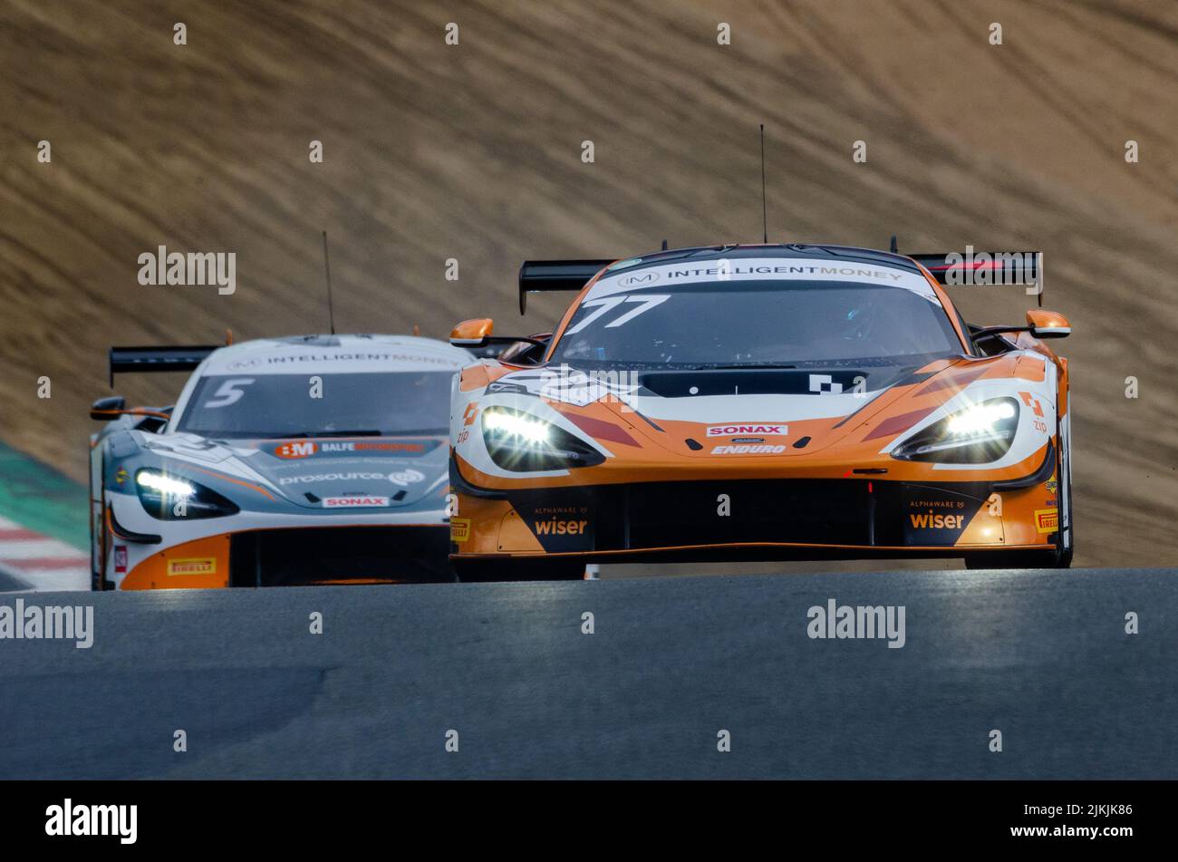 A low angle shot of two McLaren 720S orange and car during the race in ...