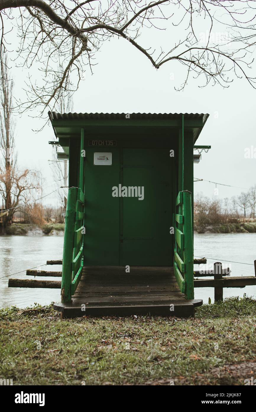 A vertical shot of a green gate near the Saint-Savinien river in France ...