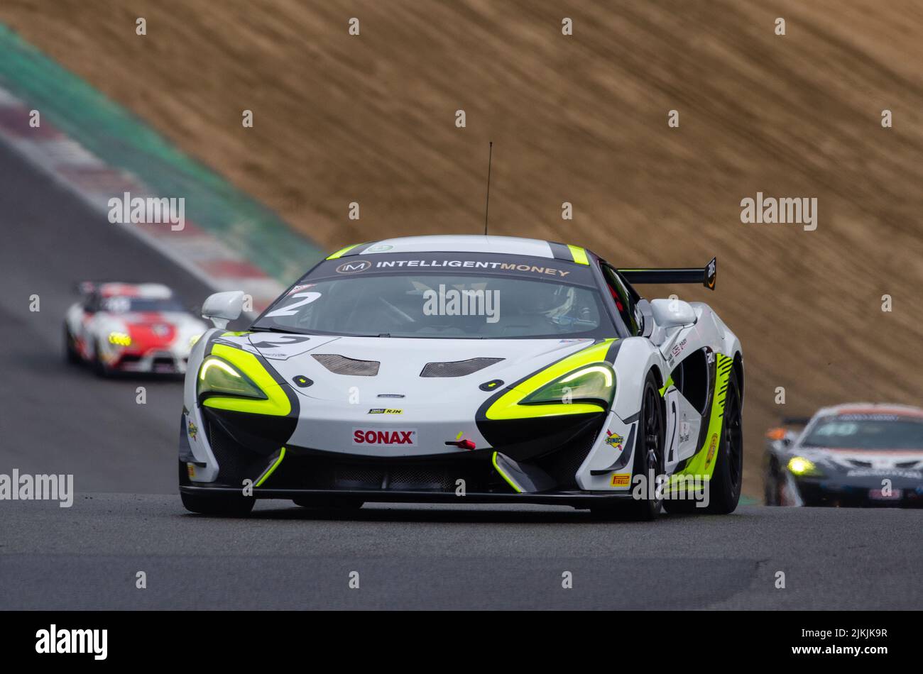 A low angle shot of a McLaren 570S white car during the race in the ...
