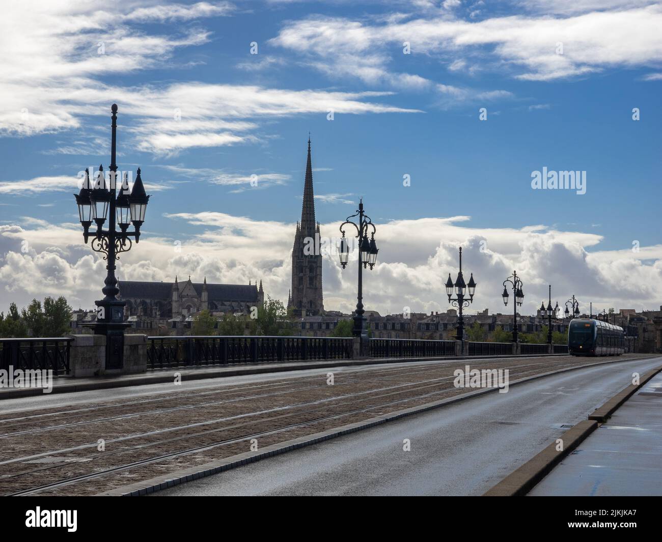 Stone bridge on the Garonne river in Bordeaux with St Michel cathedral ...