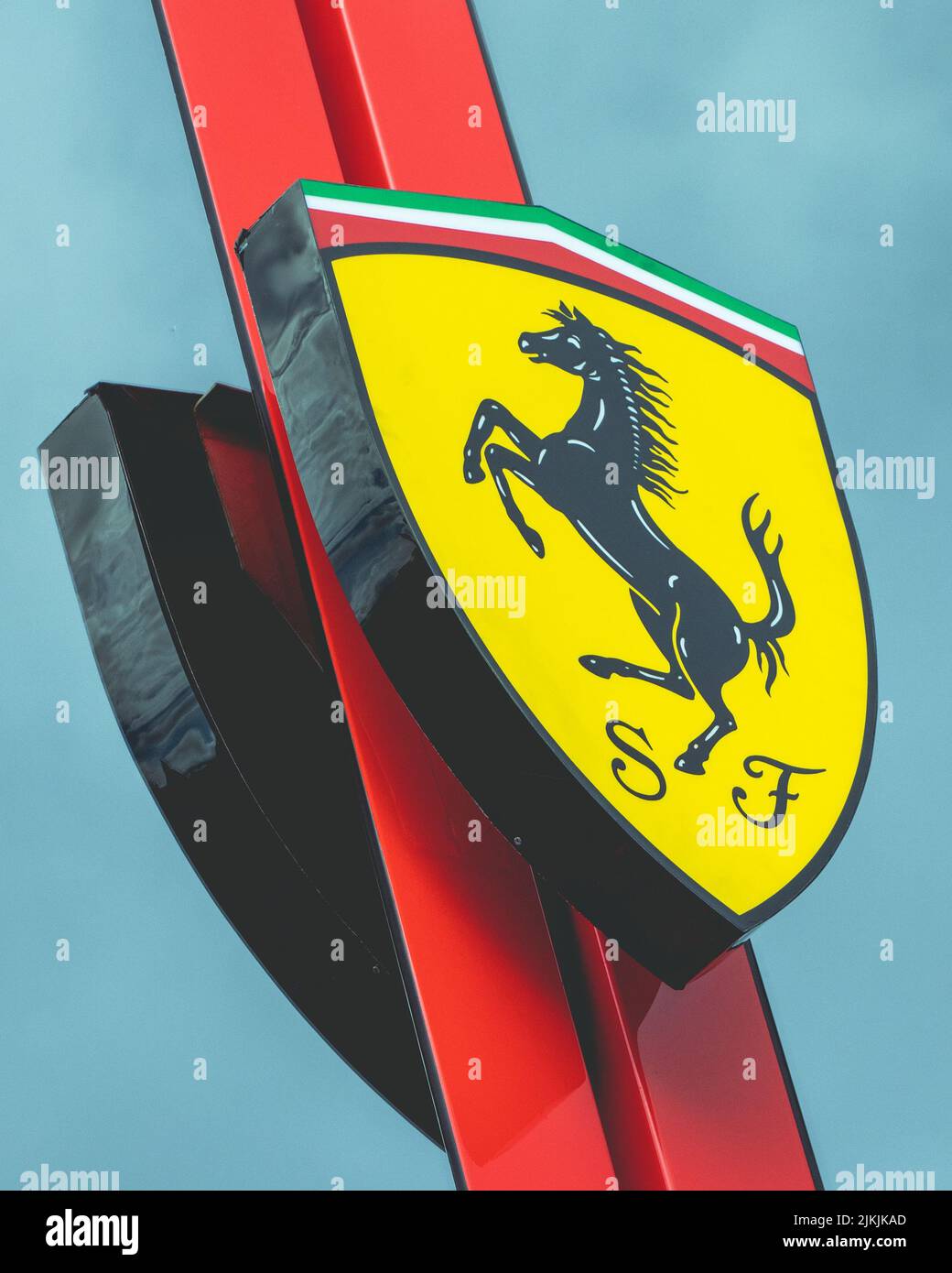 A low angle shot of the Ferrari logo against a blue sky on a sunny day ...