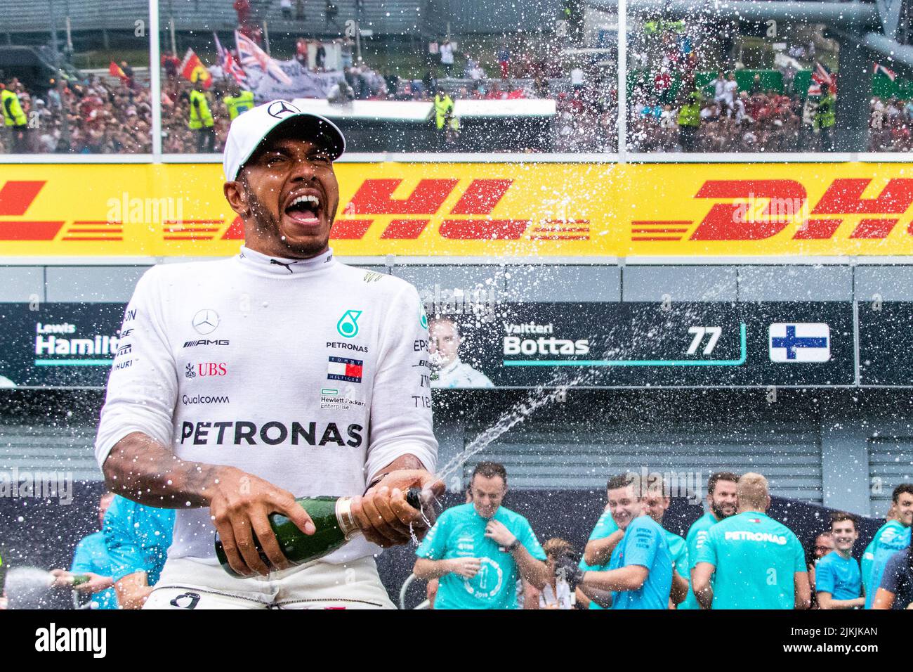 A shallow focus shot of Lewis Hamilton, and opening champagne ...