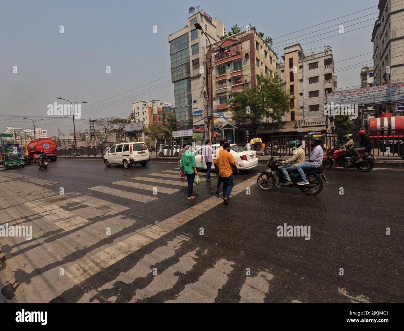 A beautiful shot of People crossing the street and people on a bike in Dhaka City, Bangladesh ...