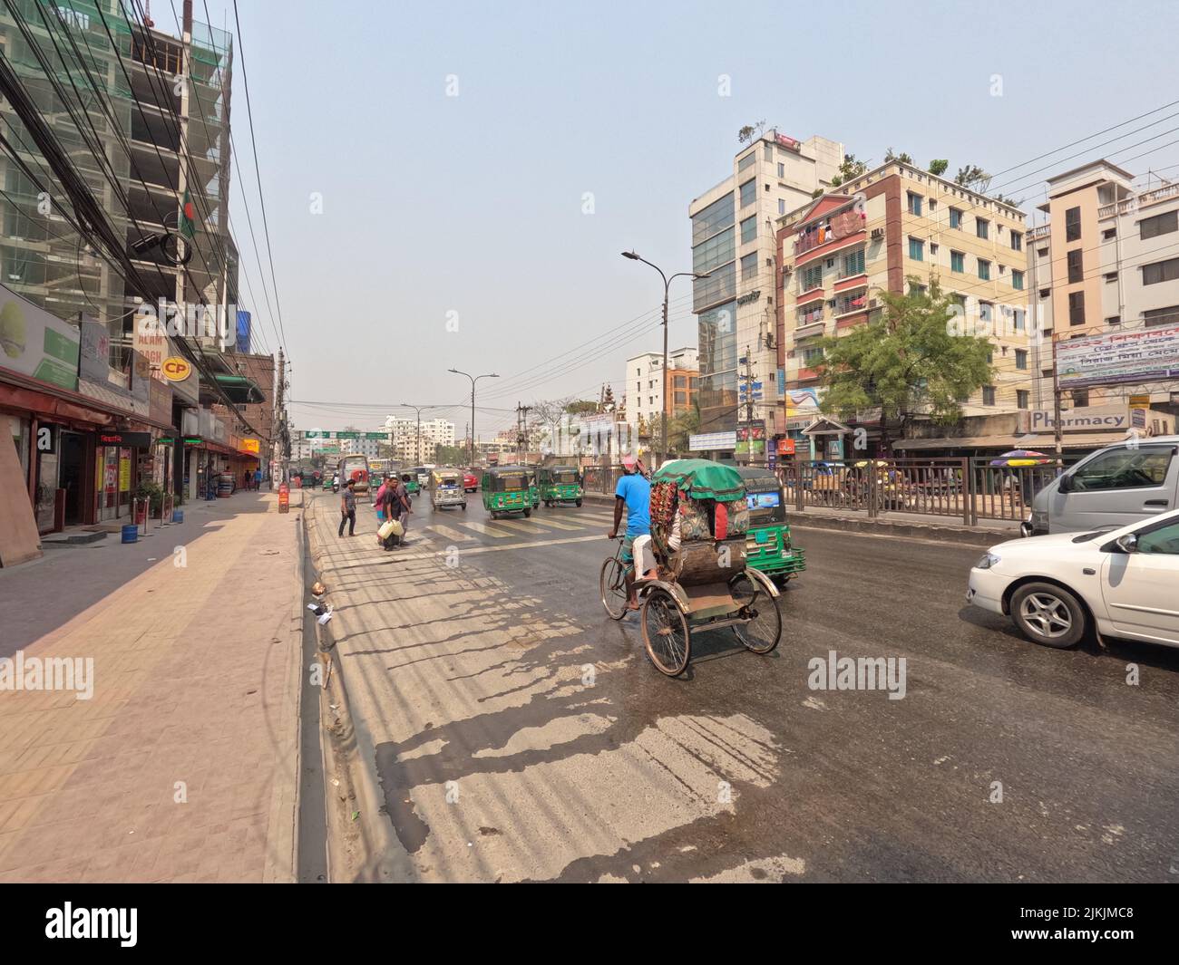 A beautiful shot of a Rickshaw Puller transporting in the street in ...