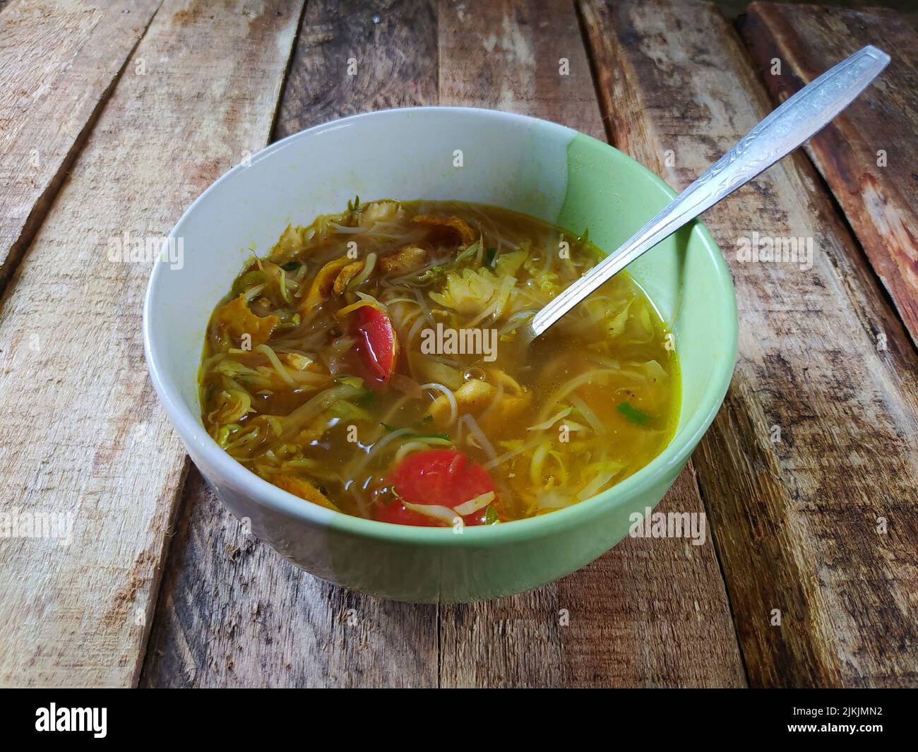 Soto kudus. Authentic clear chicken soup from Kudus on a wooden ...