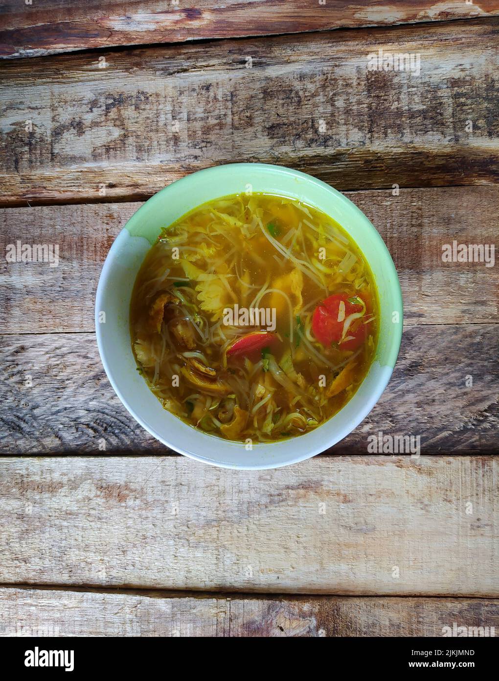 Soto kudus. Authentic clear chicken soup from Kudus on a wooden ...
