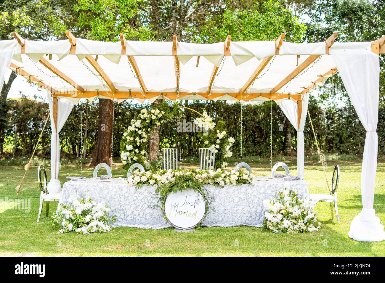 An outdoor wedding ceremony venue with an arranged table for the guests ...