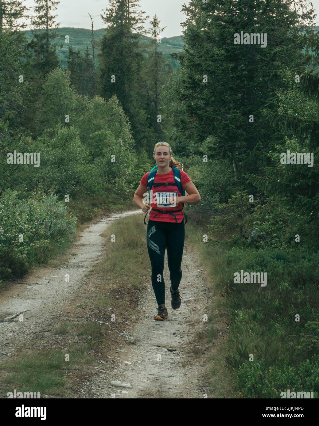 A vertical shot of a young caucasian female running a marathon on a ...
