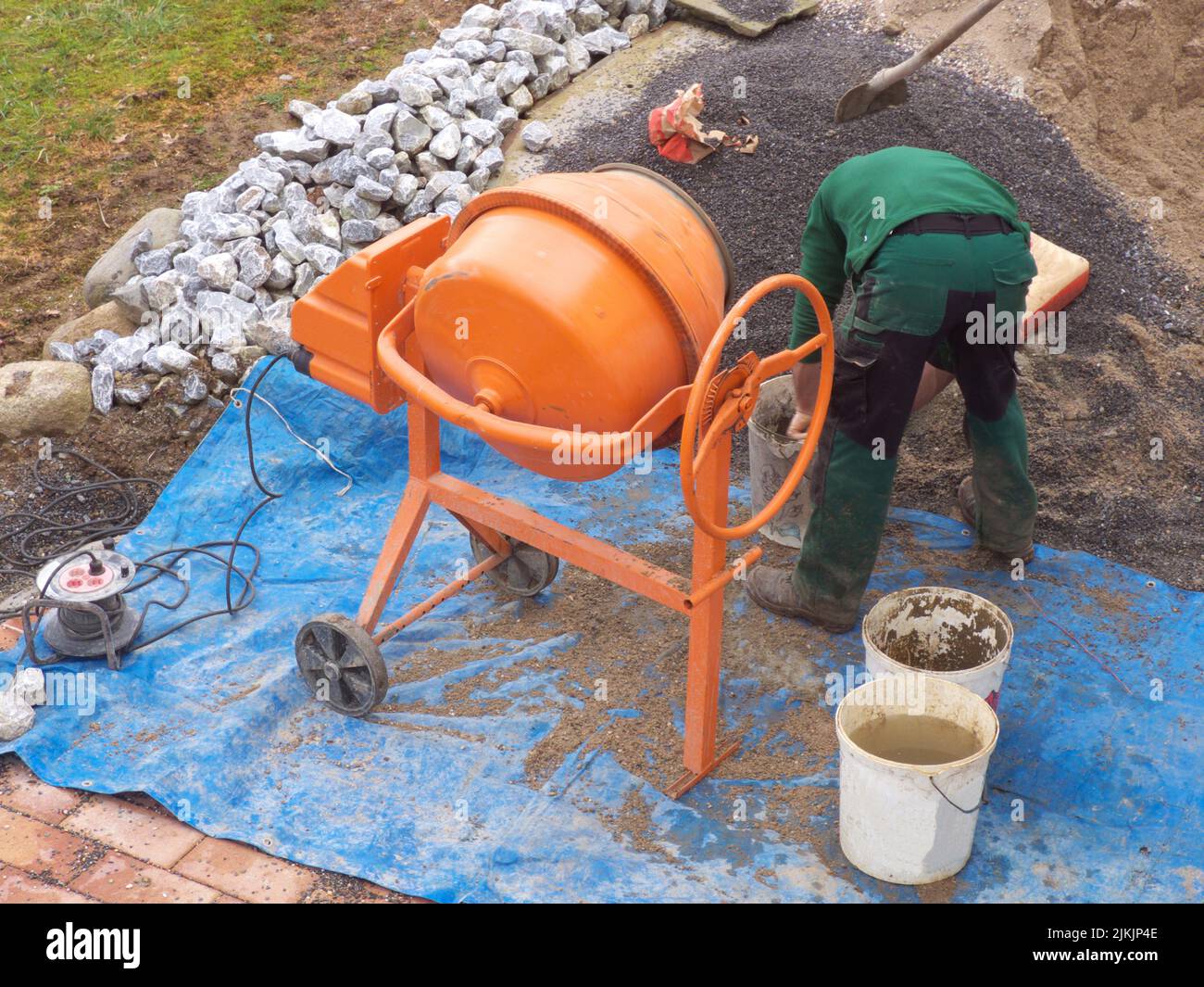 A construction worker using concrete mixers Stock Photo - Alamy