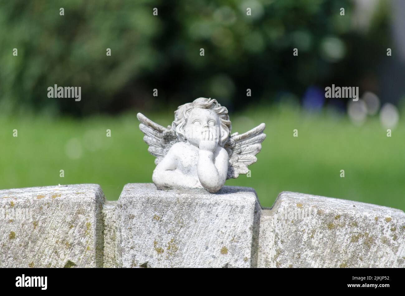 White angel figurine lying on a grave stone Stock Photo - Alamy