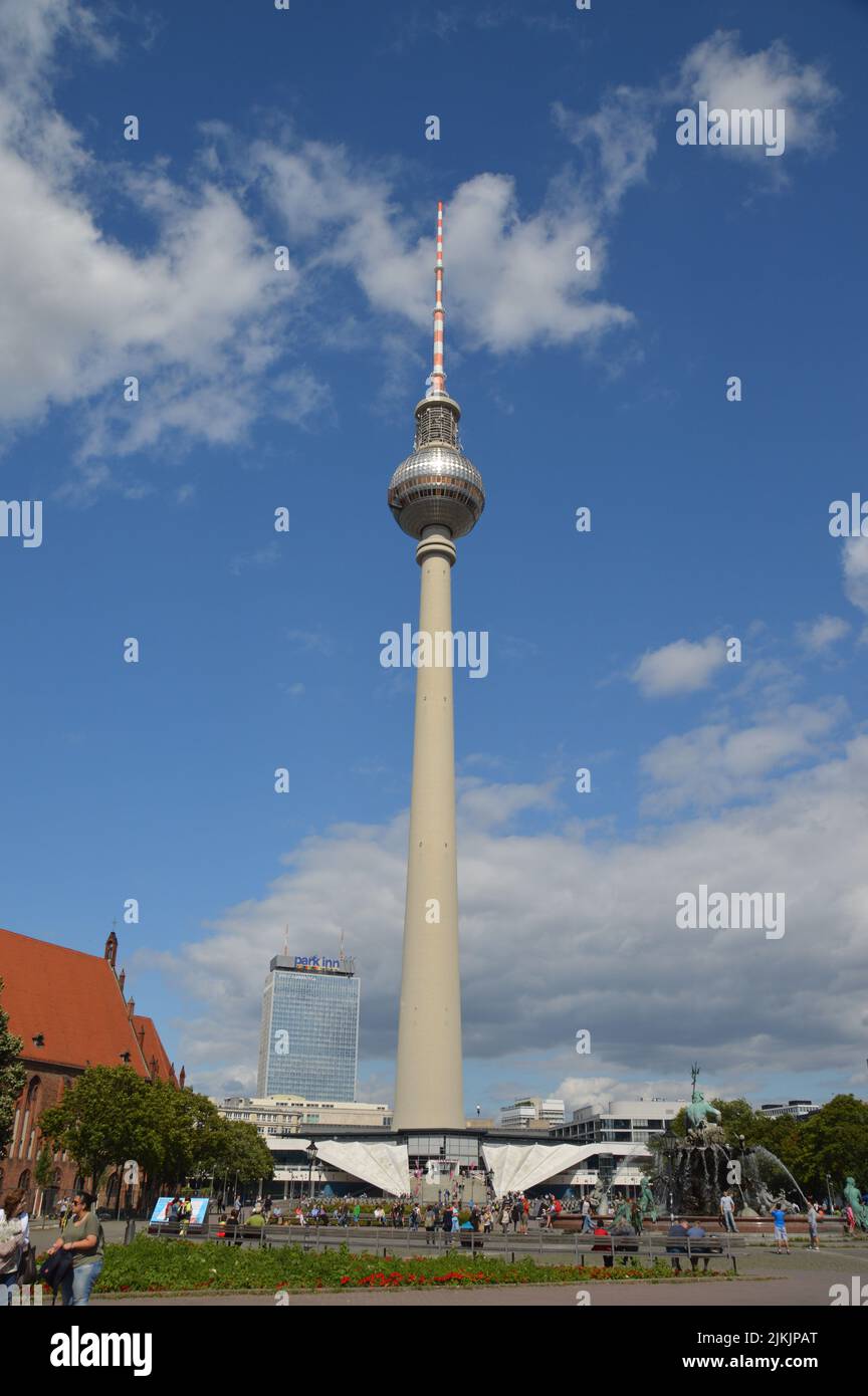 A vertical shot of the Berliner Fernsehturm against blue sky in bright ...