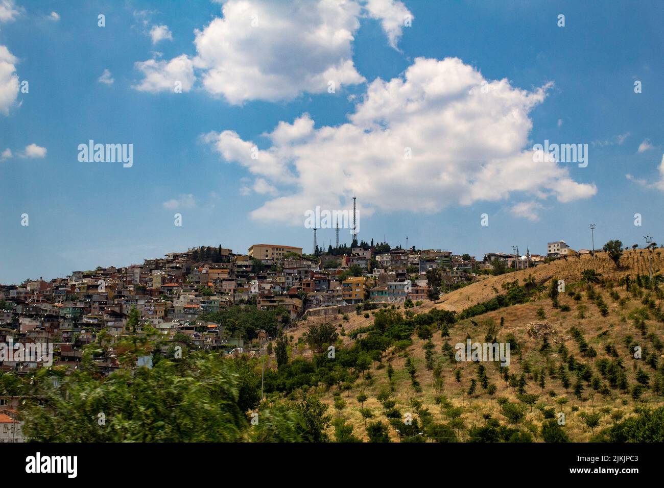 The city of Irbid with buildings, houses and trees on hills under a ...