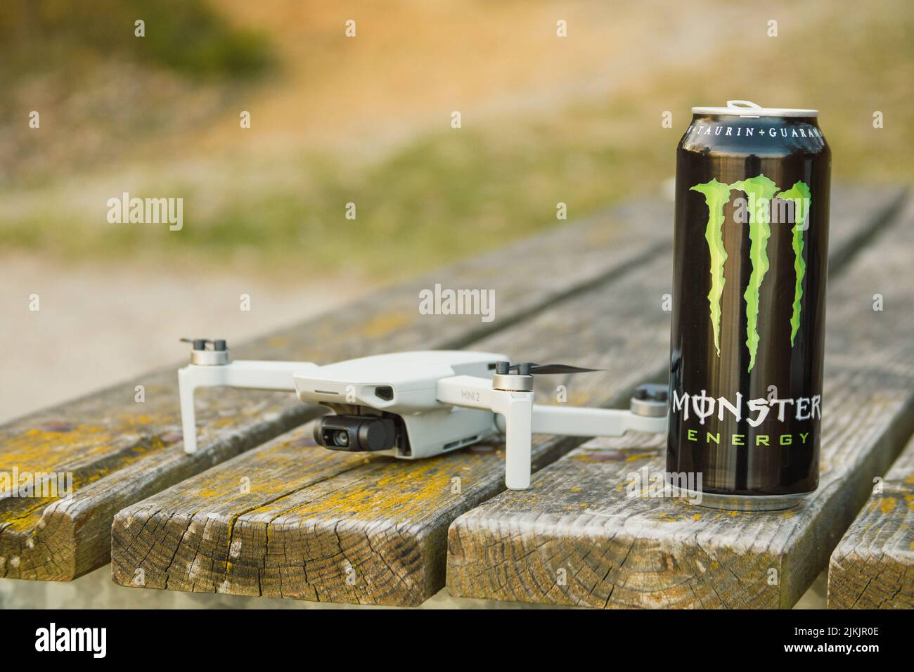 A closeup shot of a Monster energy drink on a camping table and a DJI ...