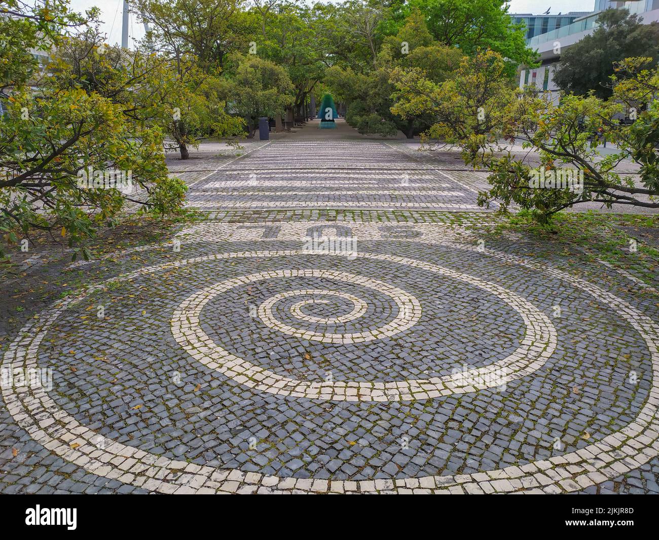 A spiral pattern of cobblestone in the park surrounded by trees Stock ...