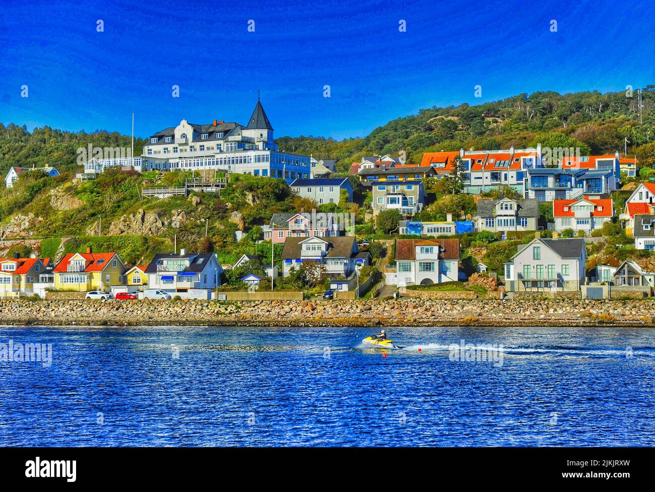 A scenic view of the Grand Hotel with buildings and the harbor in the ...