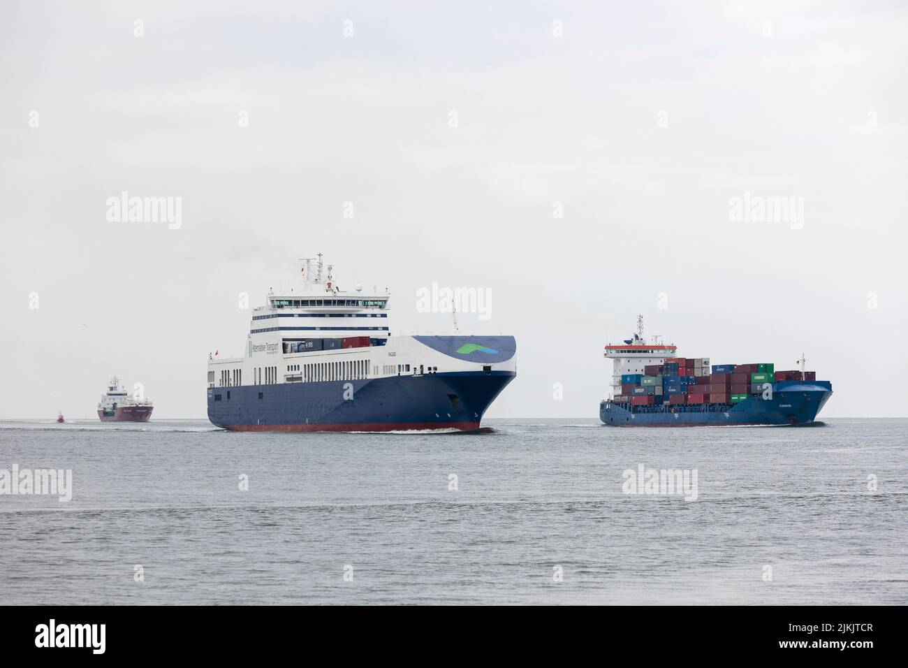 A ferry and a ship full of containers sailing on the River Elbe in ...