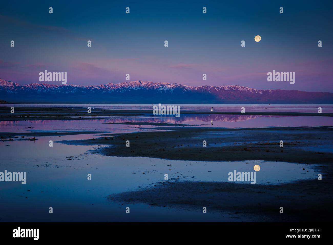 A Blue clouds over the sea. Tinted seascape. Sky and moon reflected in ...