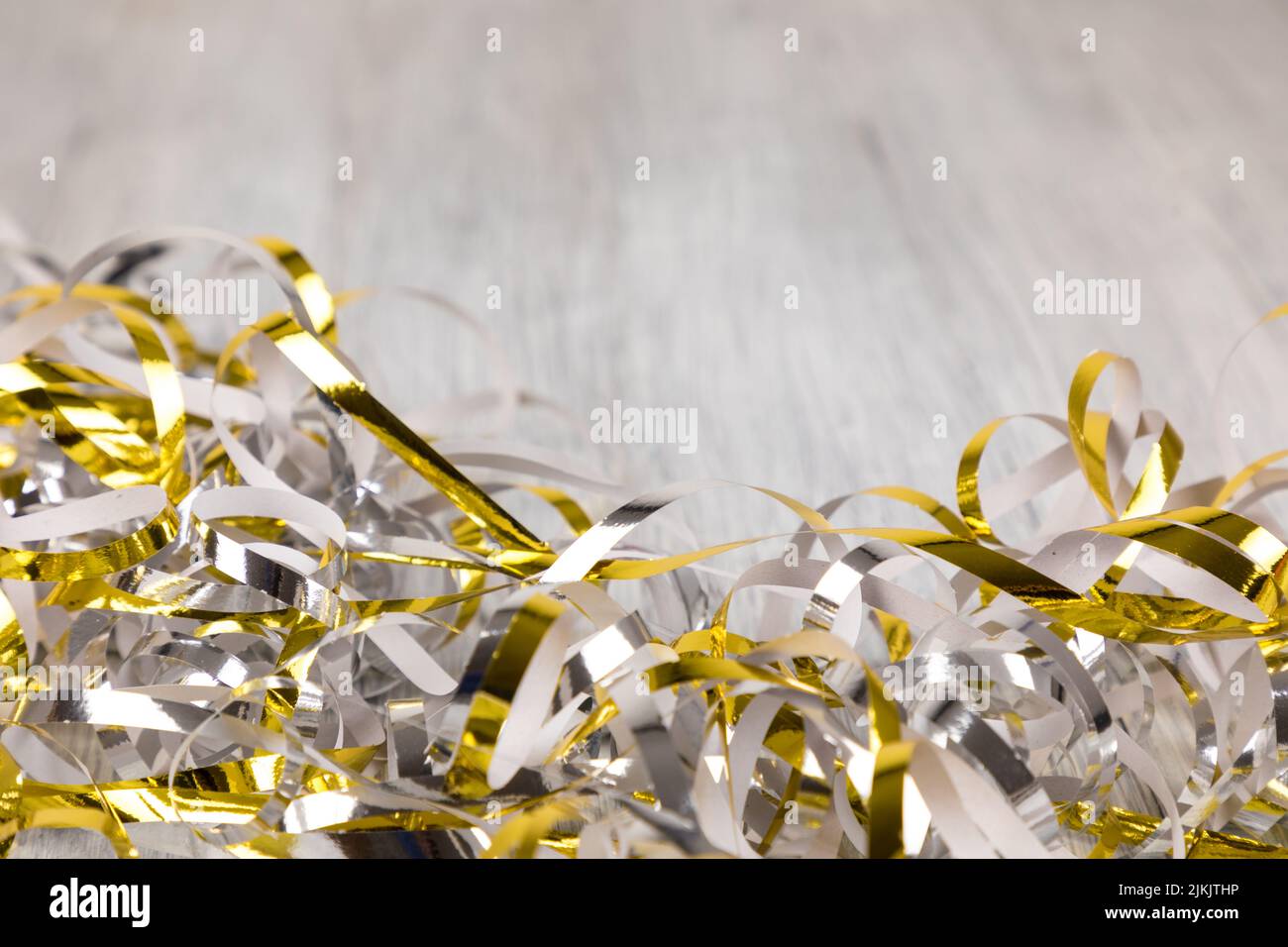 A New Year white wooden background with gold and silver streamers and ...