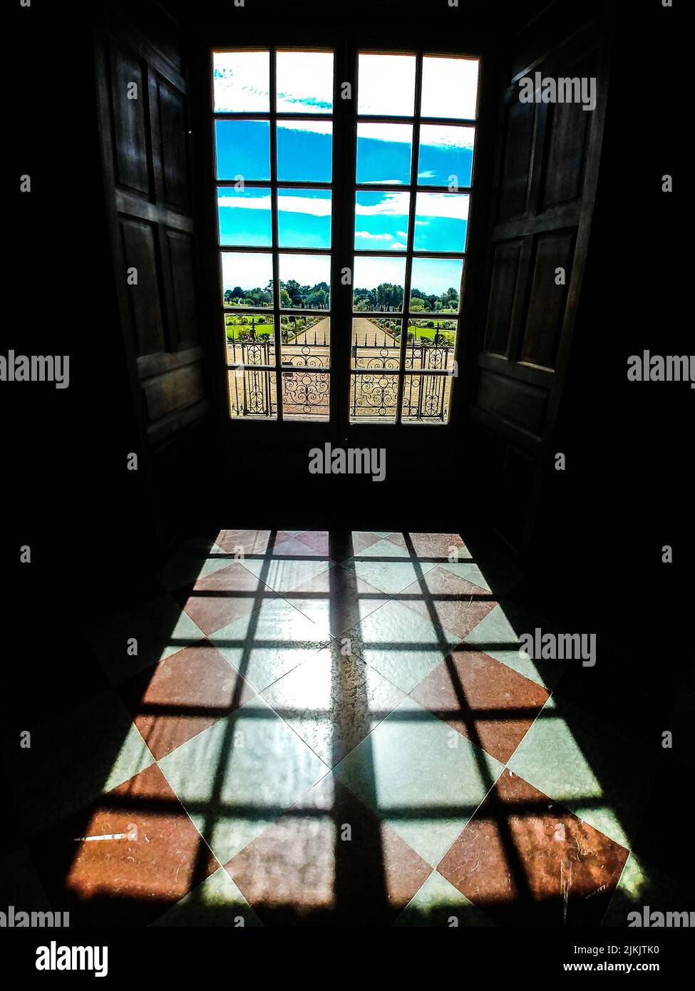 A dark room lit by bright light coming through the window and leaving a ...