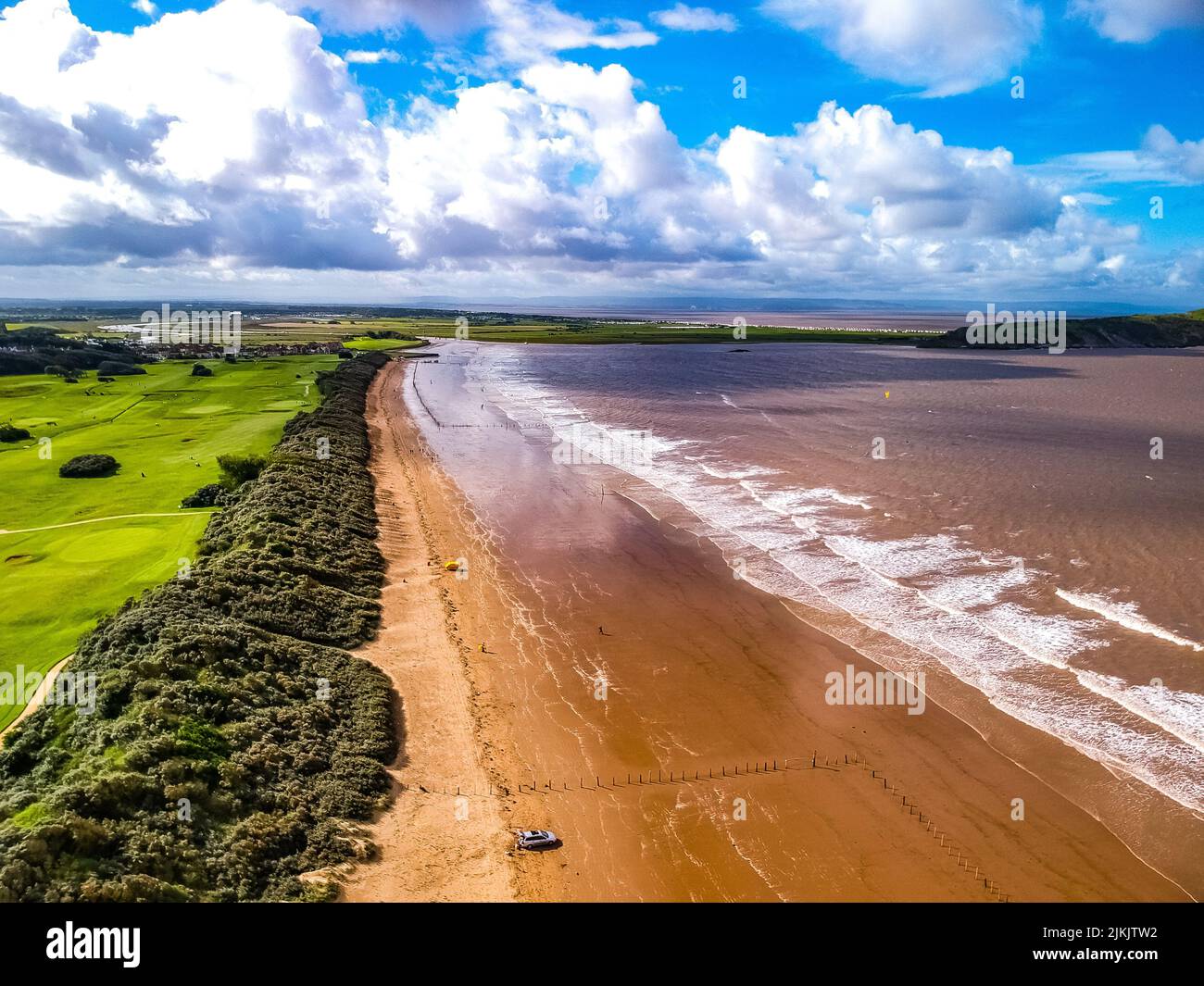 A Bird's-eye view of green fields and houses near the beach on the ...