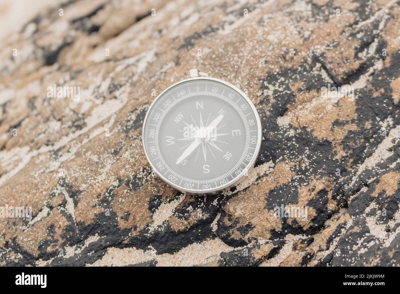 Closeup, analogical compass on a rock, concept orientation, summer ...