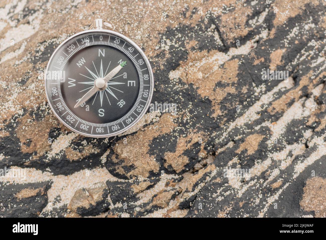 Closeup, analogical compass on a rock, concept orientation, summer ...