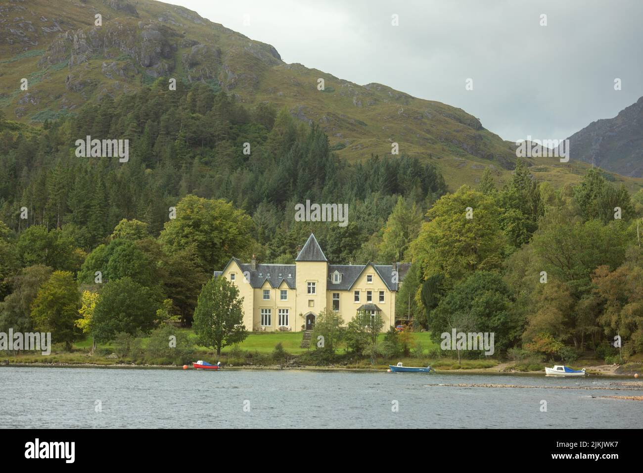 A scenic view of a mansion with the boats on the water against the ...